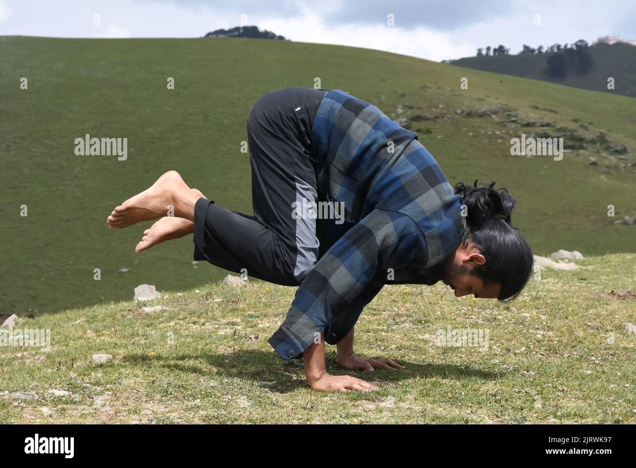 A young Indian man doing morning exercise with practicing Bakasana Yoga ...