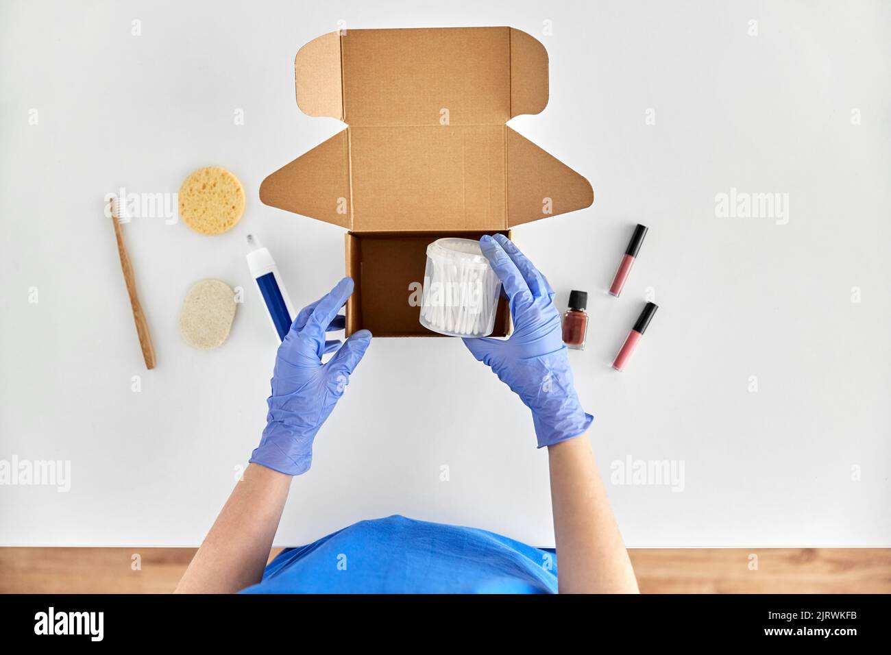 hands in gloves packing parcel box with cosmetics Stock Photo - Alamy