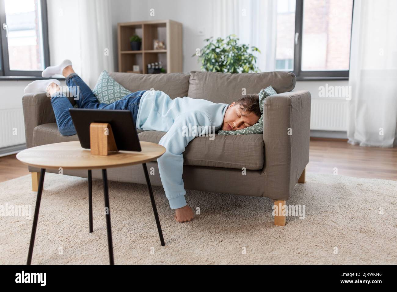 Depressed man sleeping on sofa hi-res stock photography and images - Alamy