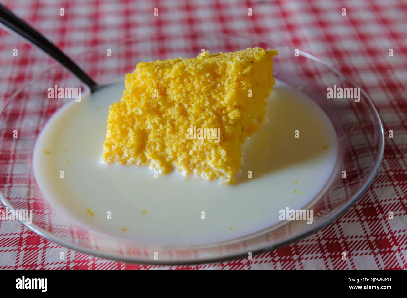 Corn couscous with milk on table with red and white tablecloth. Popular ...