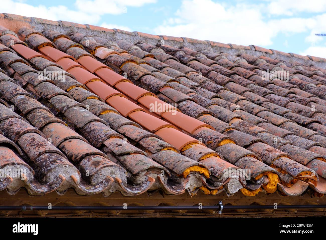 repair of old roof with new tiles and insulation foam Stock Photo - Alamy