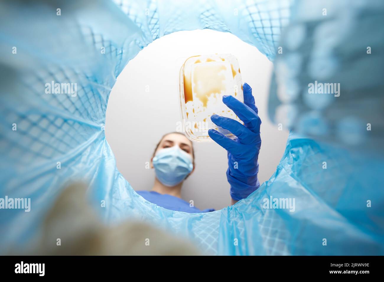 doctor throwing plastic container into trash can Stock Photo - Alamy