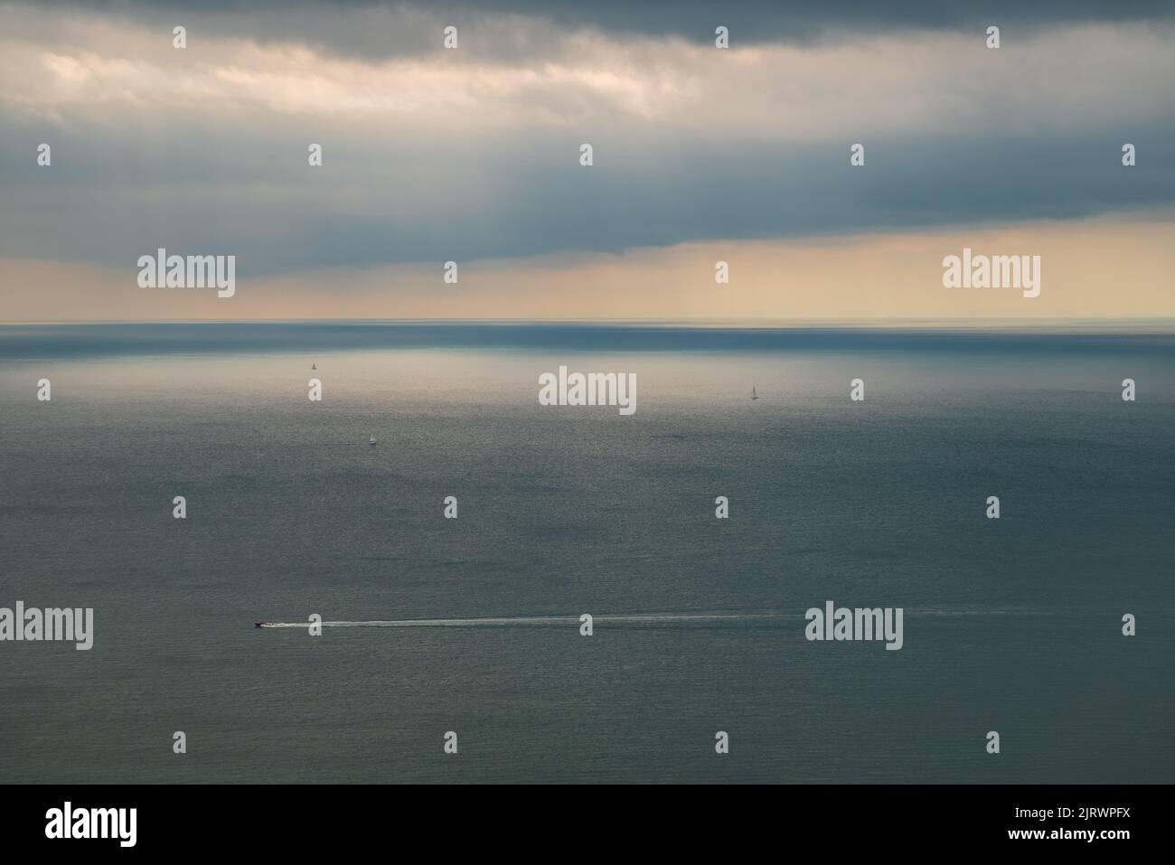 Moody, dramatic seascape with small boats, Dorset coast, England, UK ...