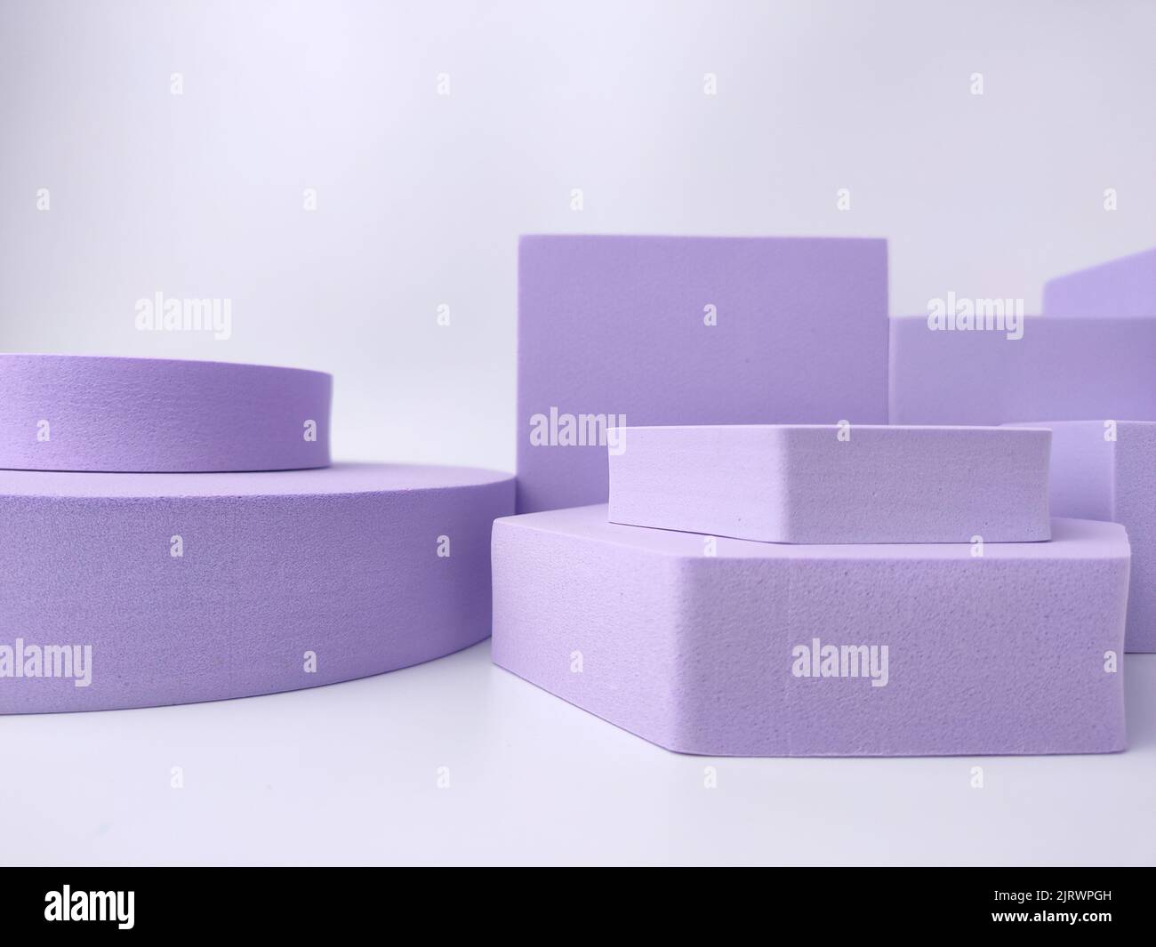 A 3D rendering of purple podiums for product presentation on white ...