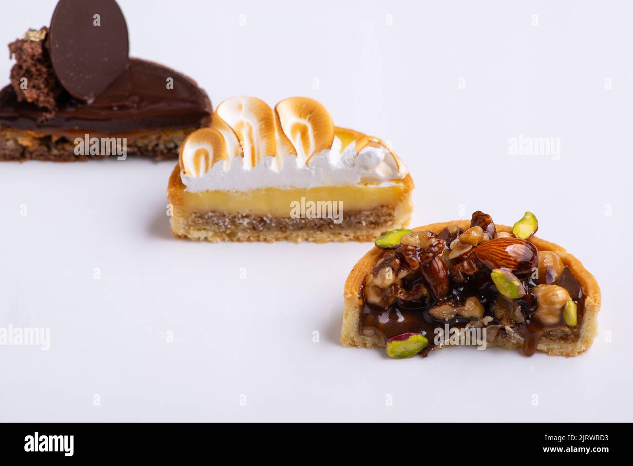 A Three pieces of cakes cut in half isolated on a white background ...