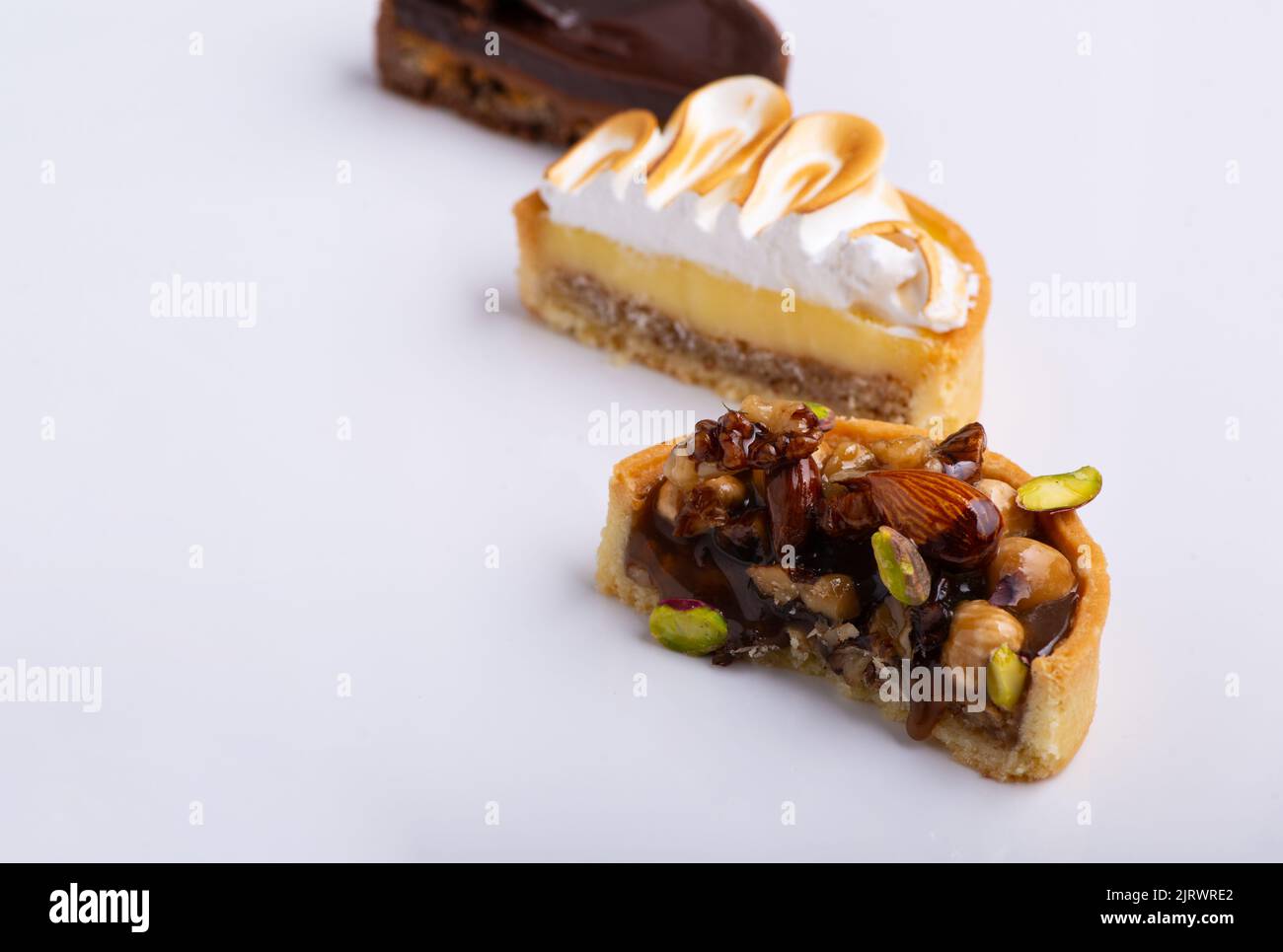 A Three pieces of cakes cut in half isolated on a white background ...