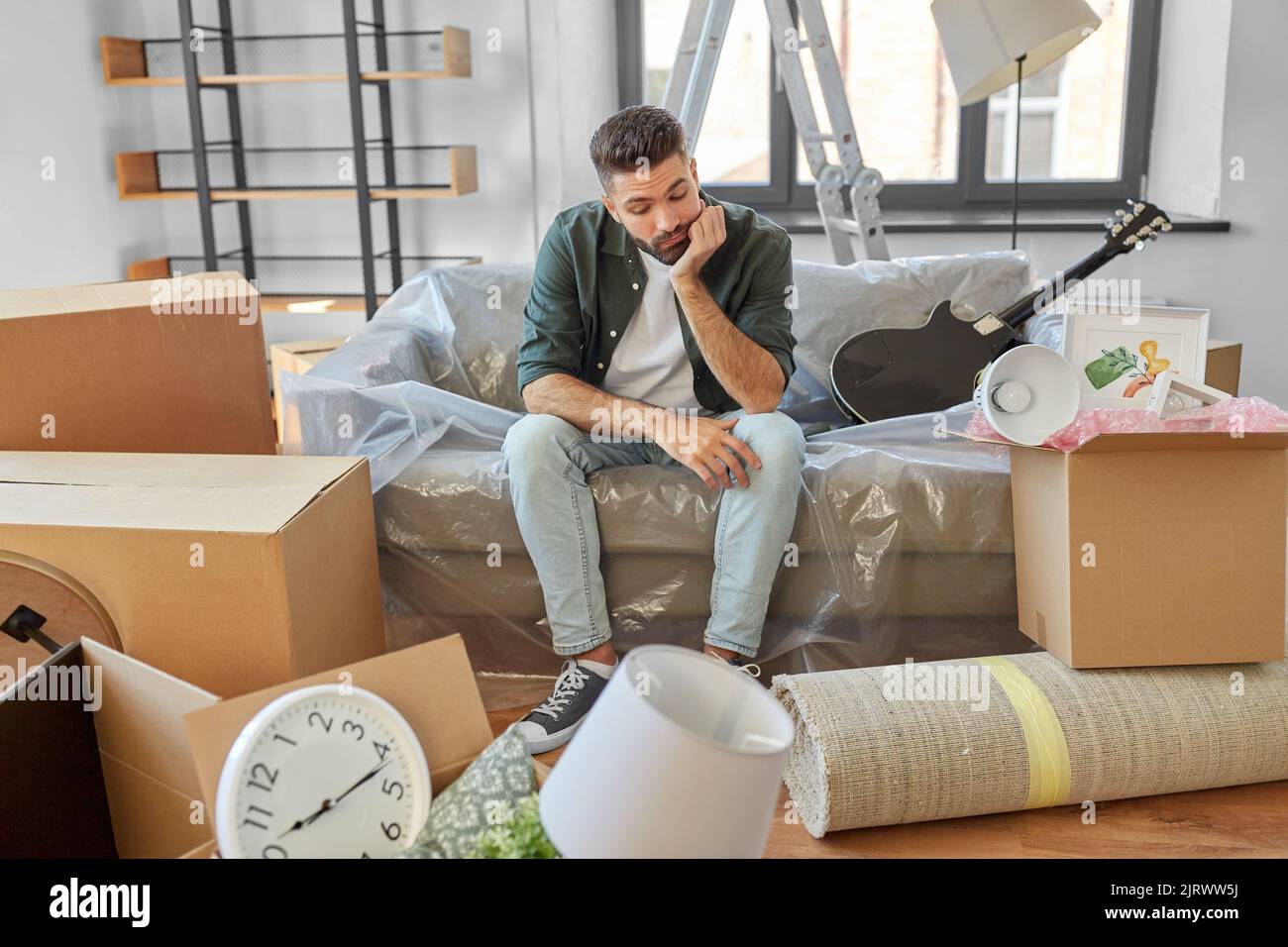 sad man with boxes moving to new home Stock Photo - Alamy