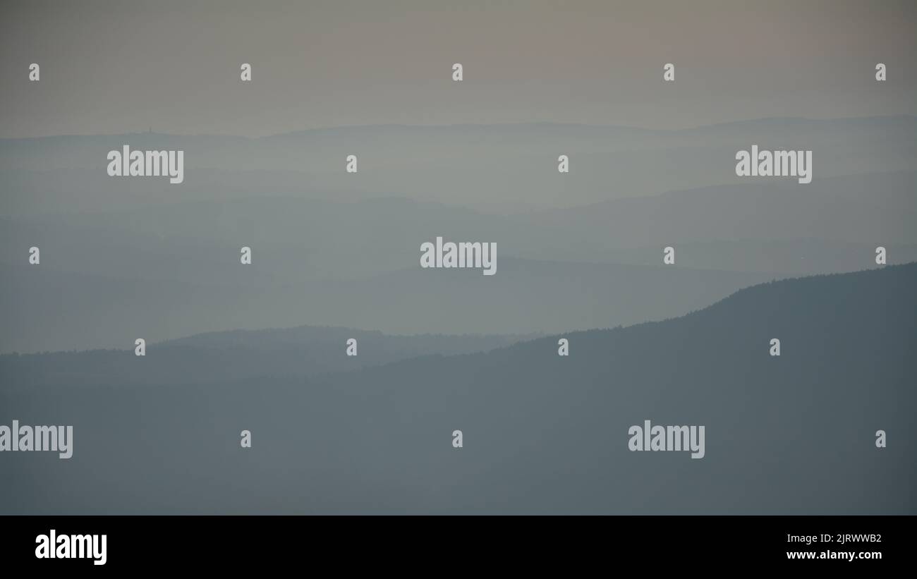 hills landscape in early morning mist forming lines like shapes outline ...