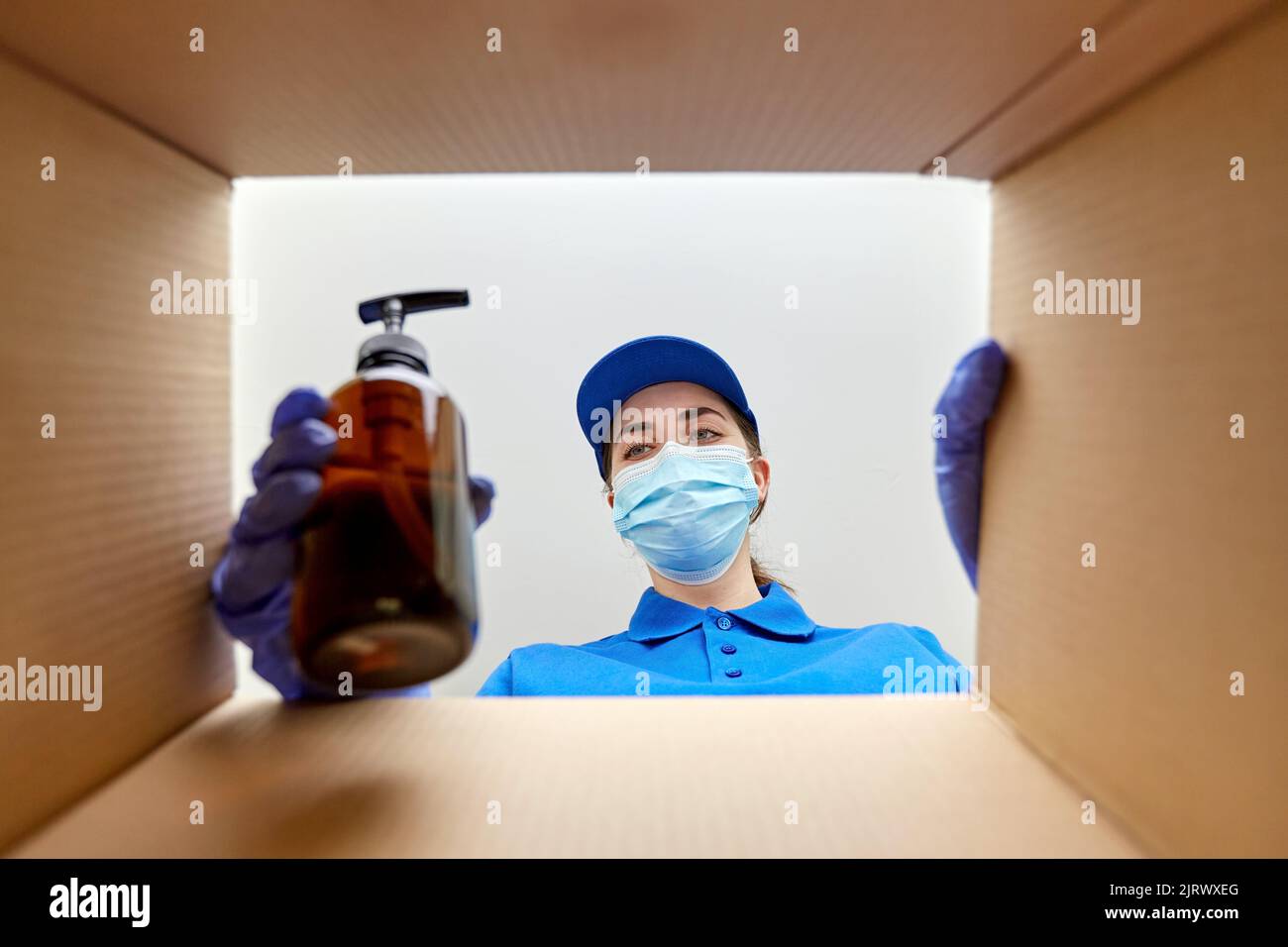 woman in mask packing parcel box with cosmetics Stock Photo - Alamy