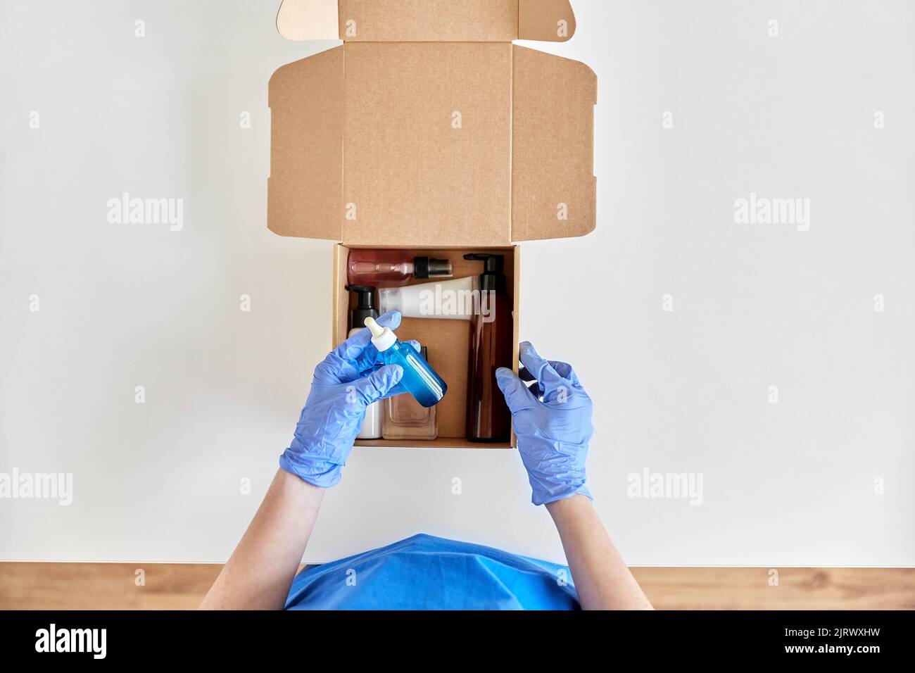 hands in gloves packing parcel box with cosmetics Stock Photo - Alamy