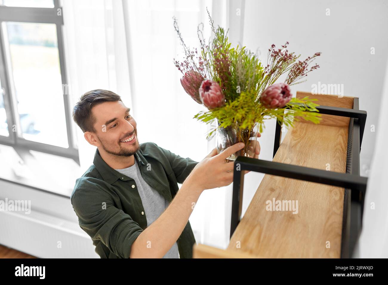 man decorating home with flowers in vase Stock Photo - Alamy