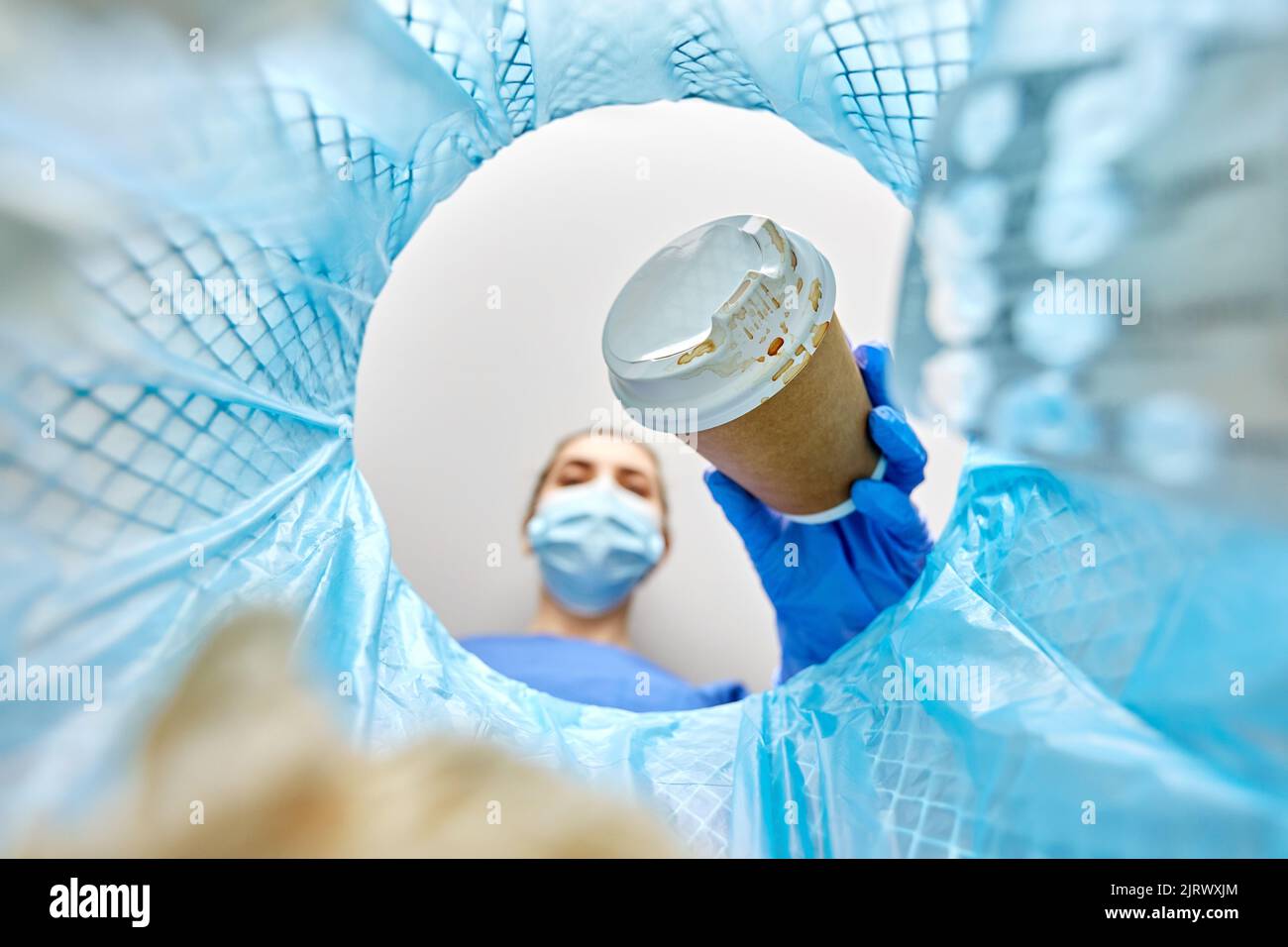 female doctor throwing coffee cup into trash can Stock Photo - Alamy