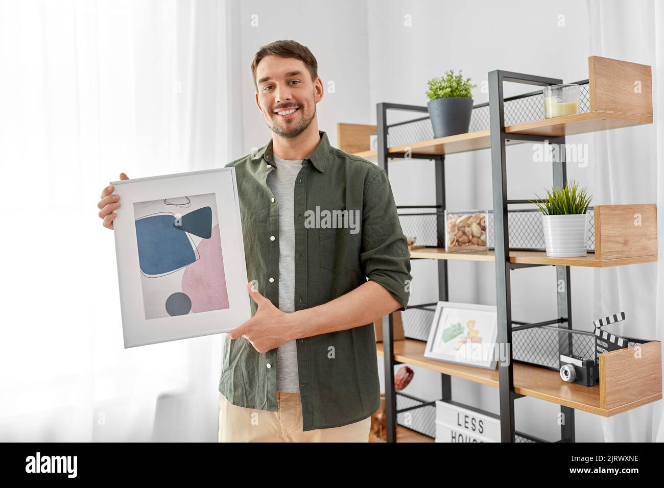 man decorating home with picture in frame Stock Photo - Alamy