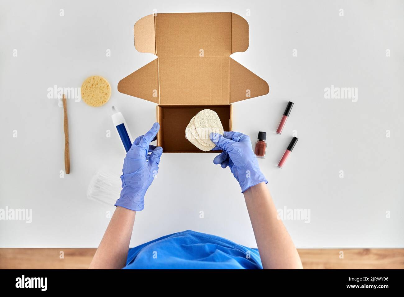 hands in gloves packing parcel box with cosmetics Stock Photo - Alamy