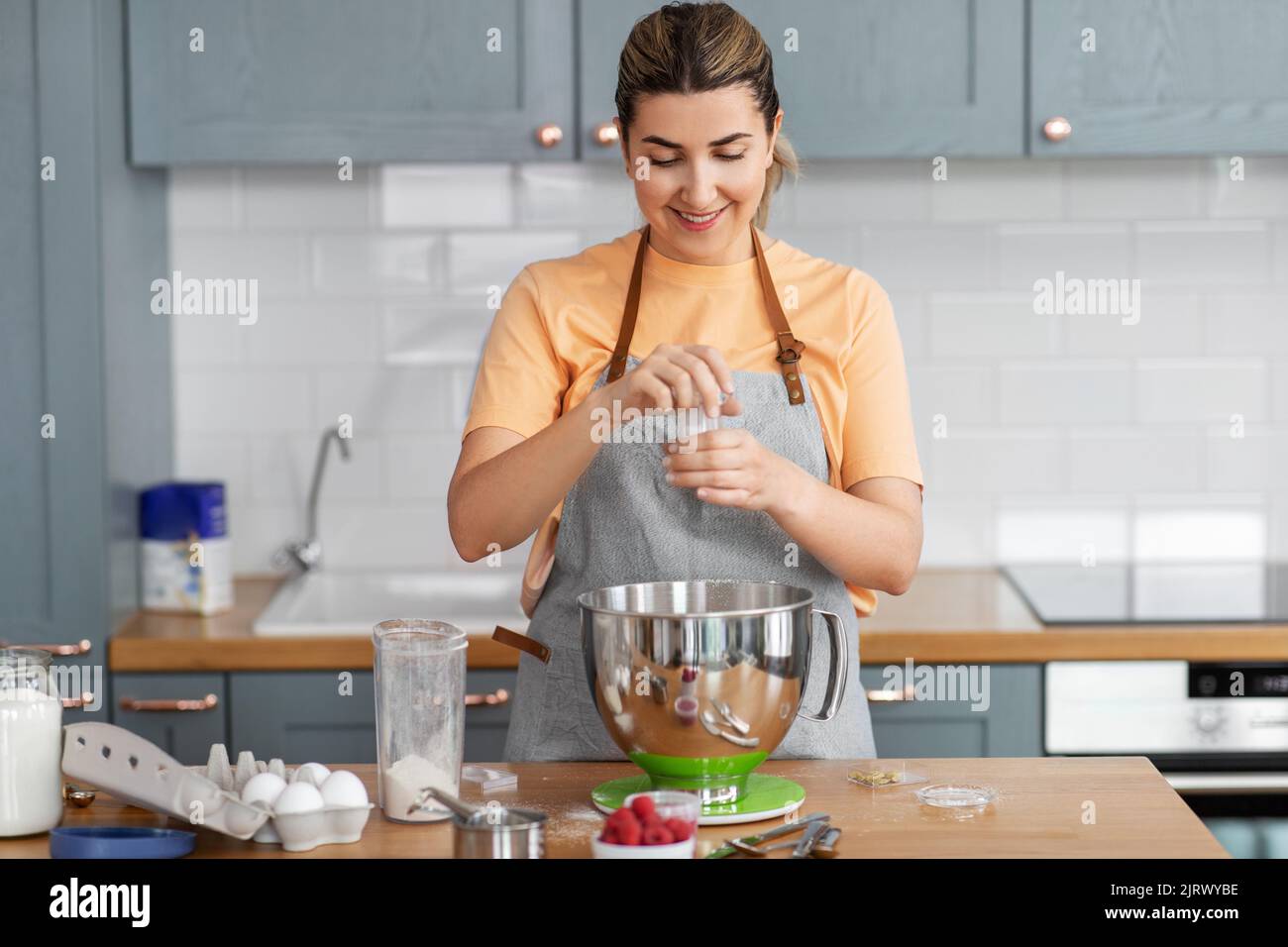 happy young woman cooking food on kitchen at home Stock Photo - Alamy