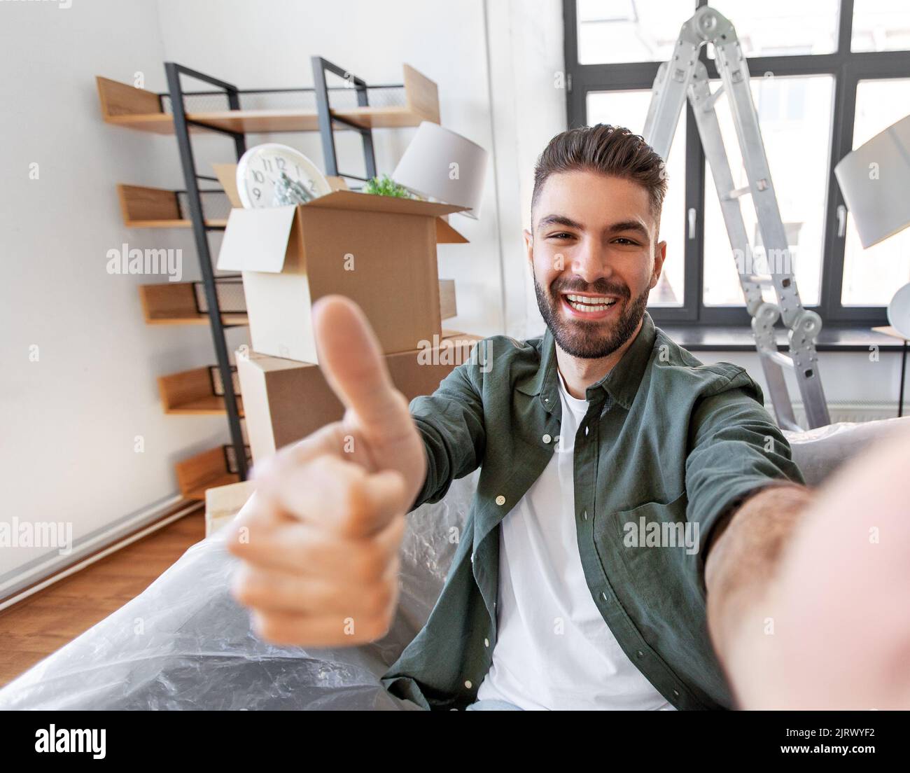 man having video call and moving into new home Stock Photo - Alamy
