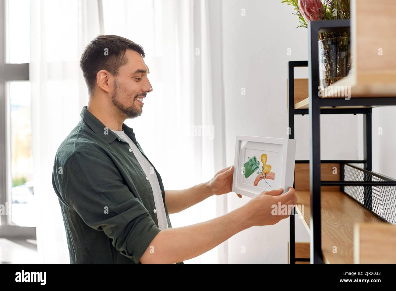 man decorating home with picture in frame Stock Photo - Alamy
