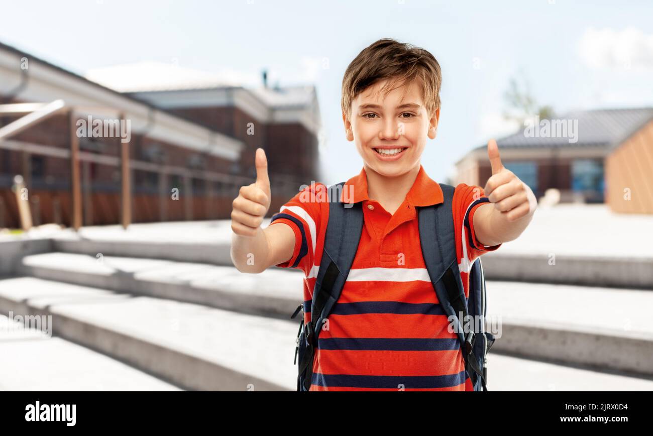 happy student boy with backpack showing thumbs up Stock Photo - Alamy
