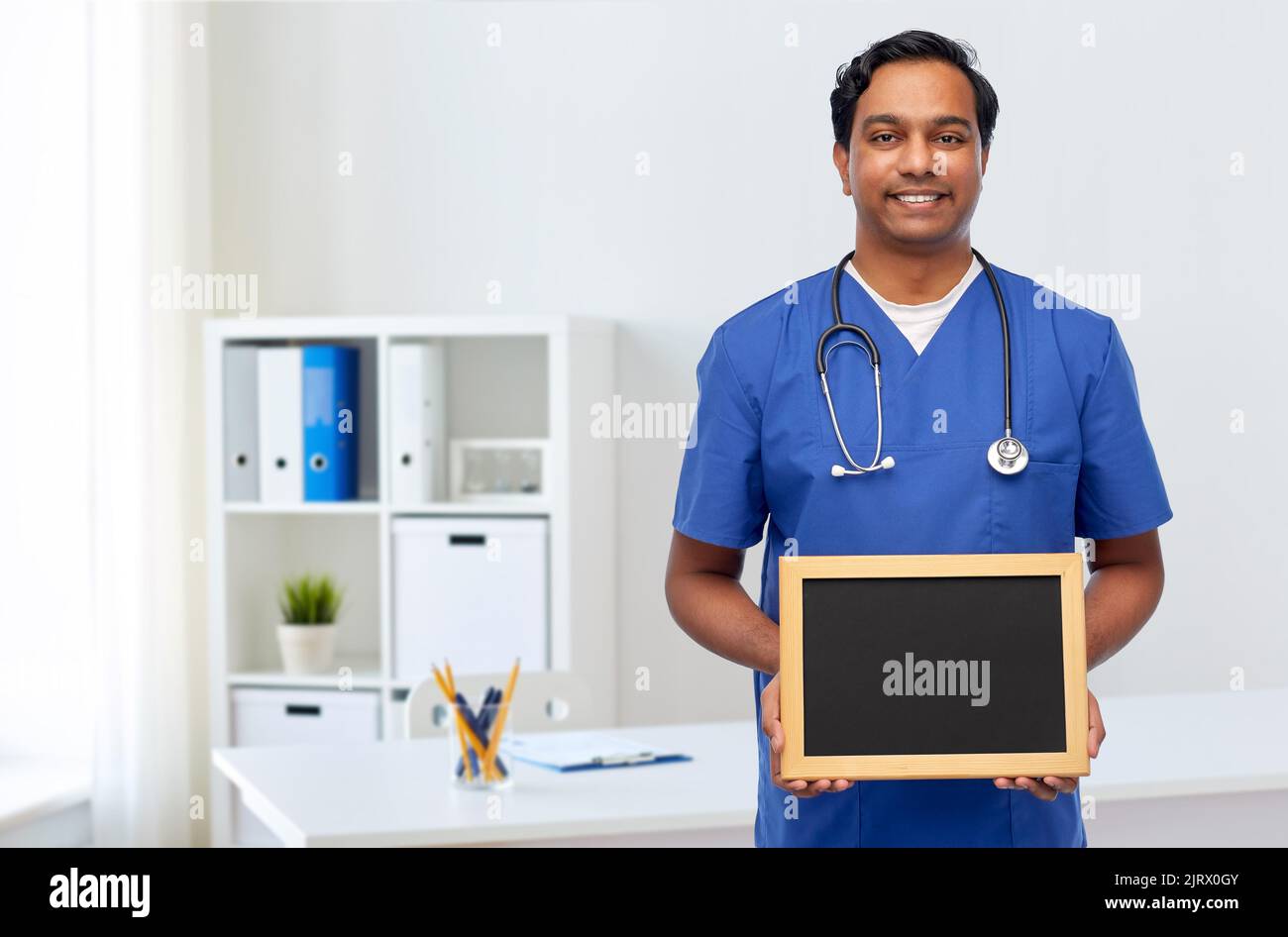 happy indian male doctor or nurse with chalkboard Stock Photo - Alamy