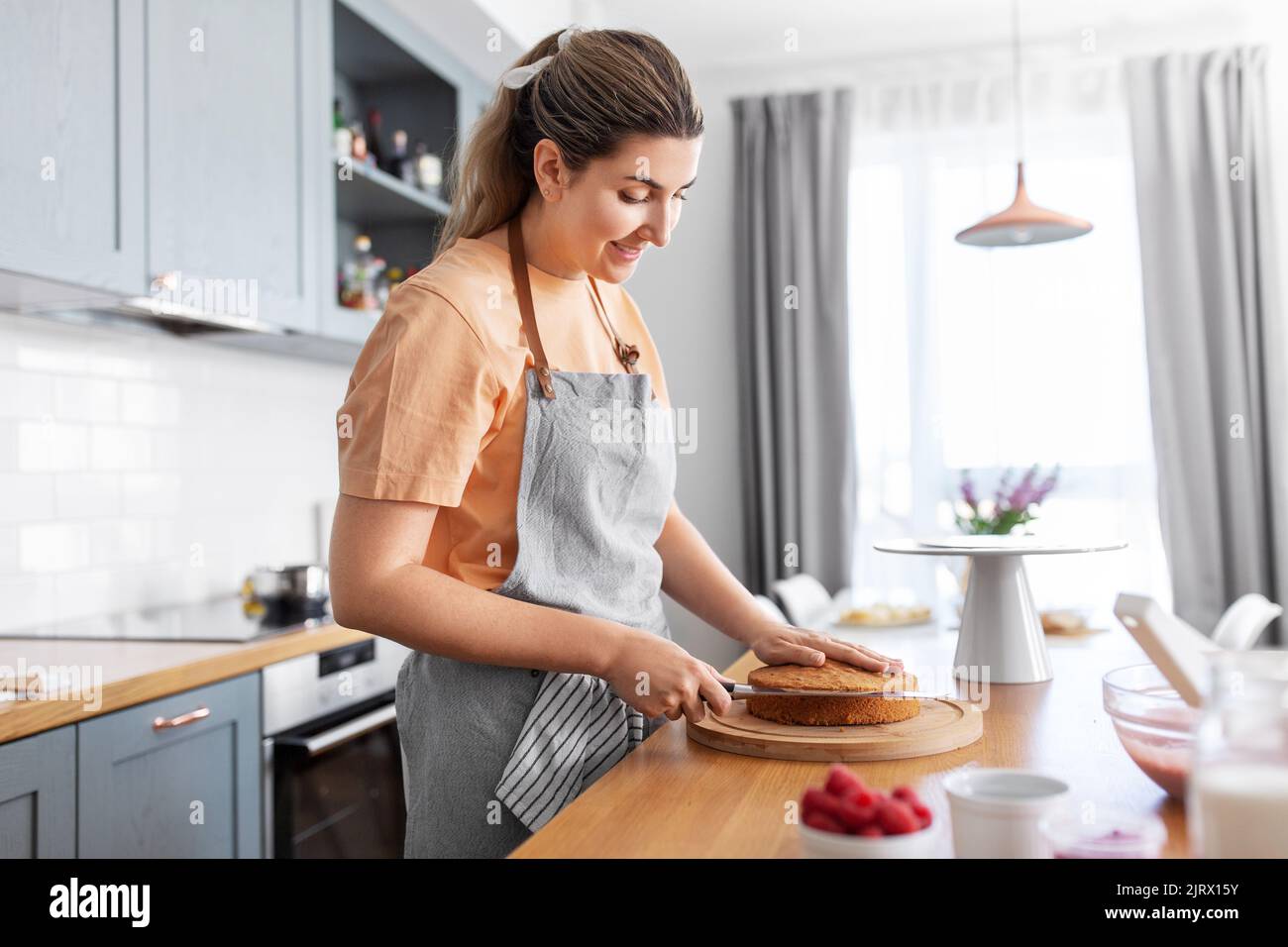 Young woman cutting home baked cake hi-res stock photography and images ...