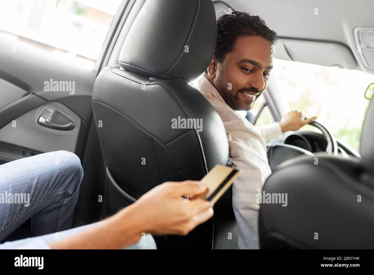 passenger giving credit card to male car driver Stock Photo - Alamy