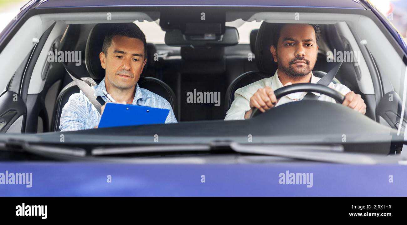 car driving school instructor and young driver Stock Photo - Alamy