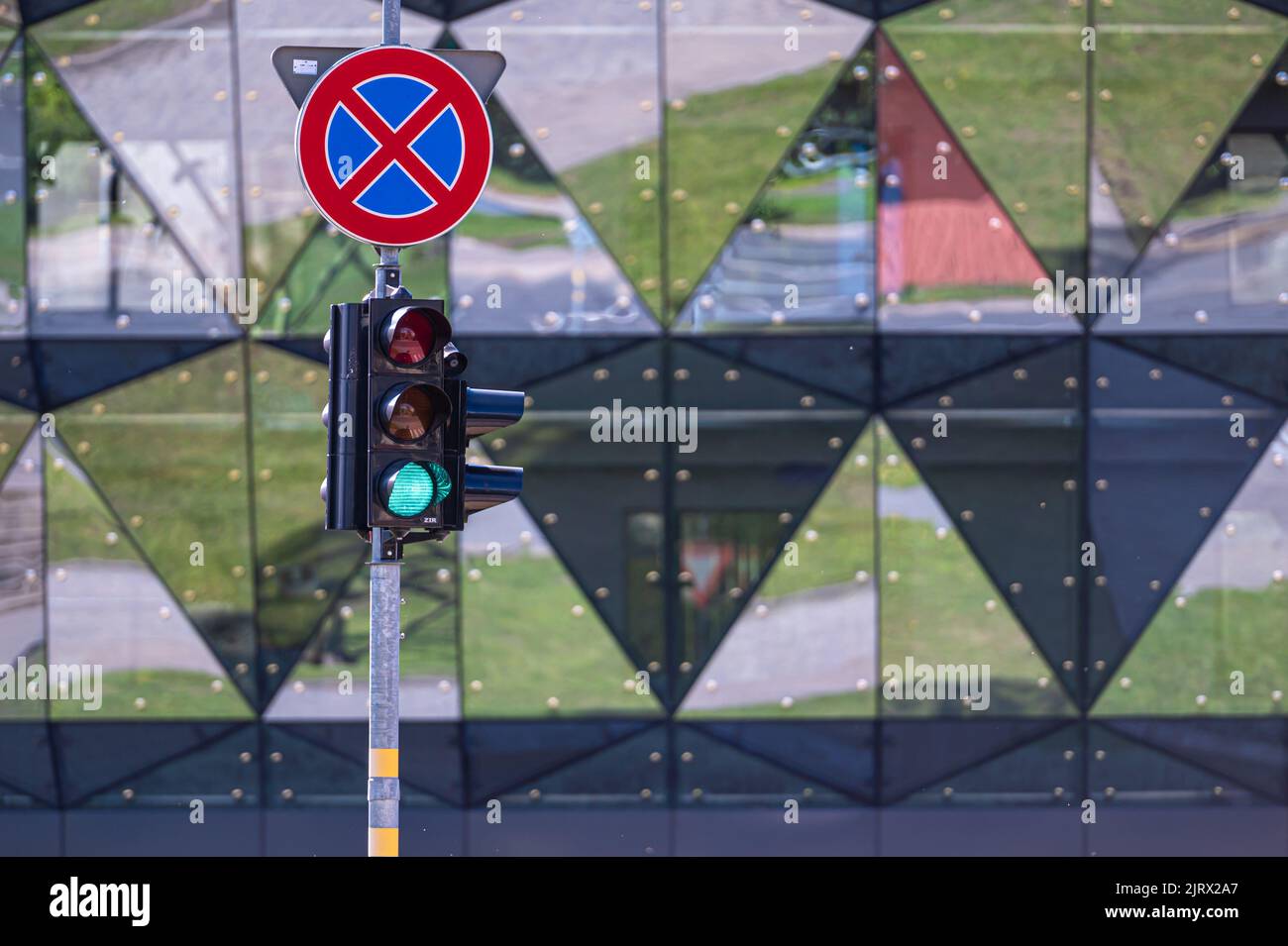 the traffic sign and semaphore with red light on the urban background ...