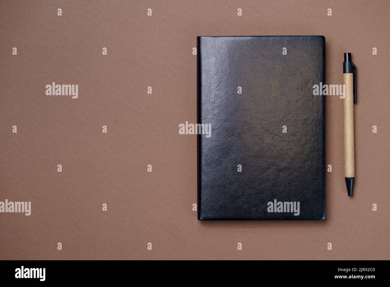 Black leather notebook on a paper brown background, notepad mock up ...