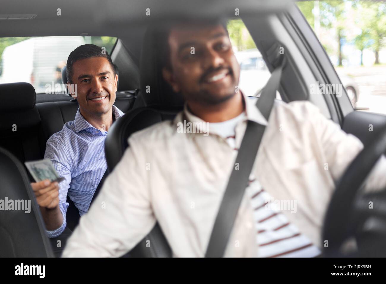 smiling passenger giving money to taxi car driver Stock Photo - Alamy
