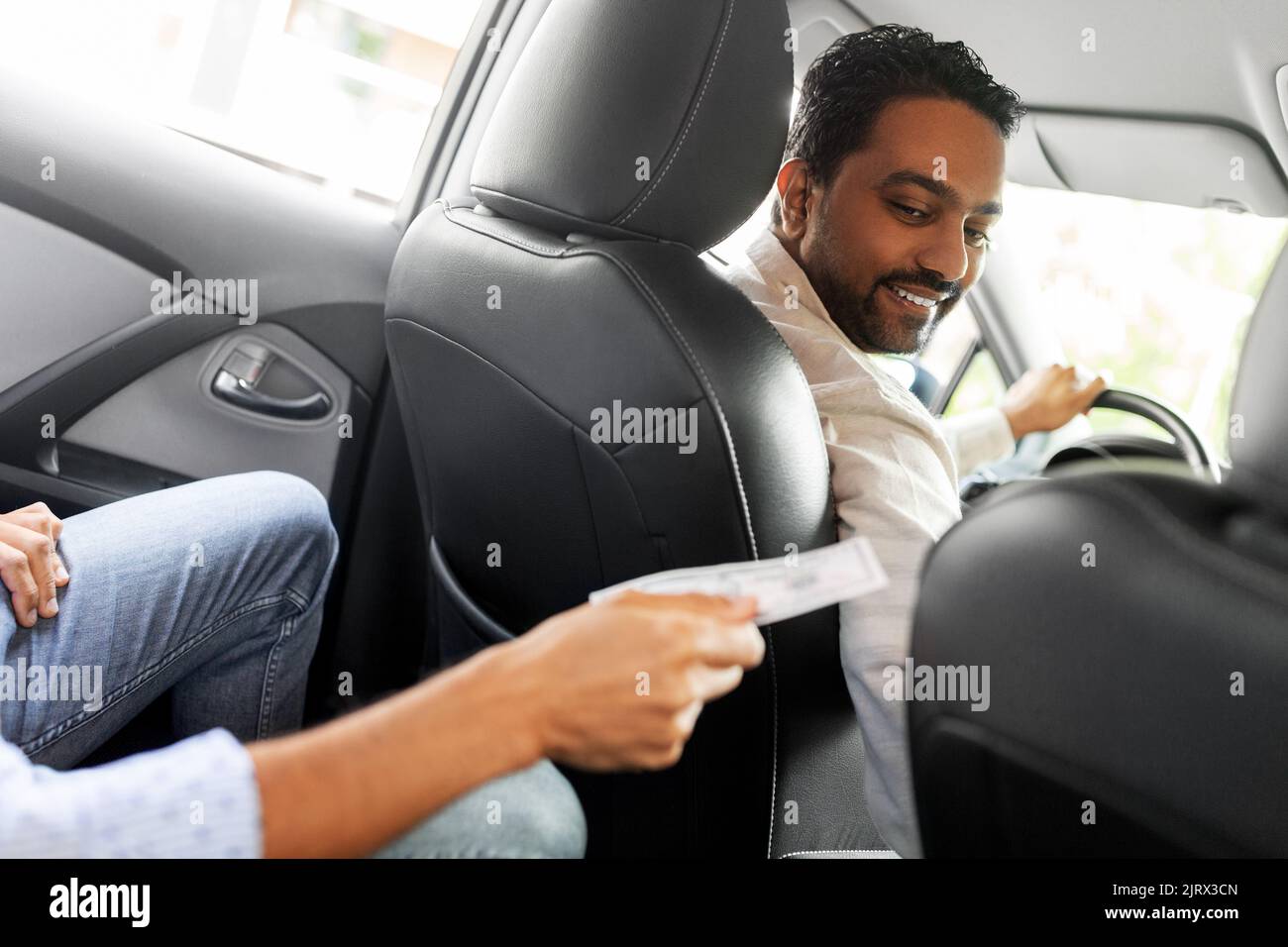 passenger giving money to smiling taxi car driver Stock Photo - Alamy