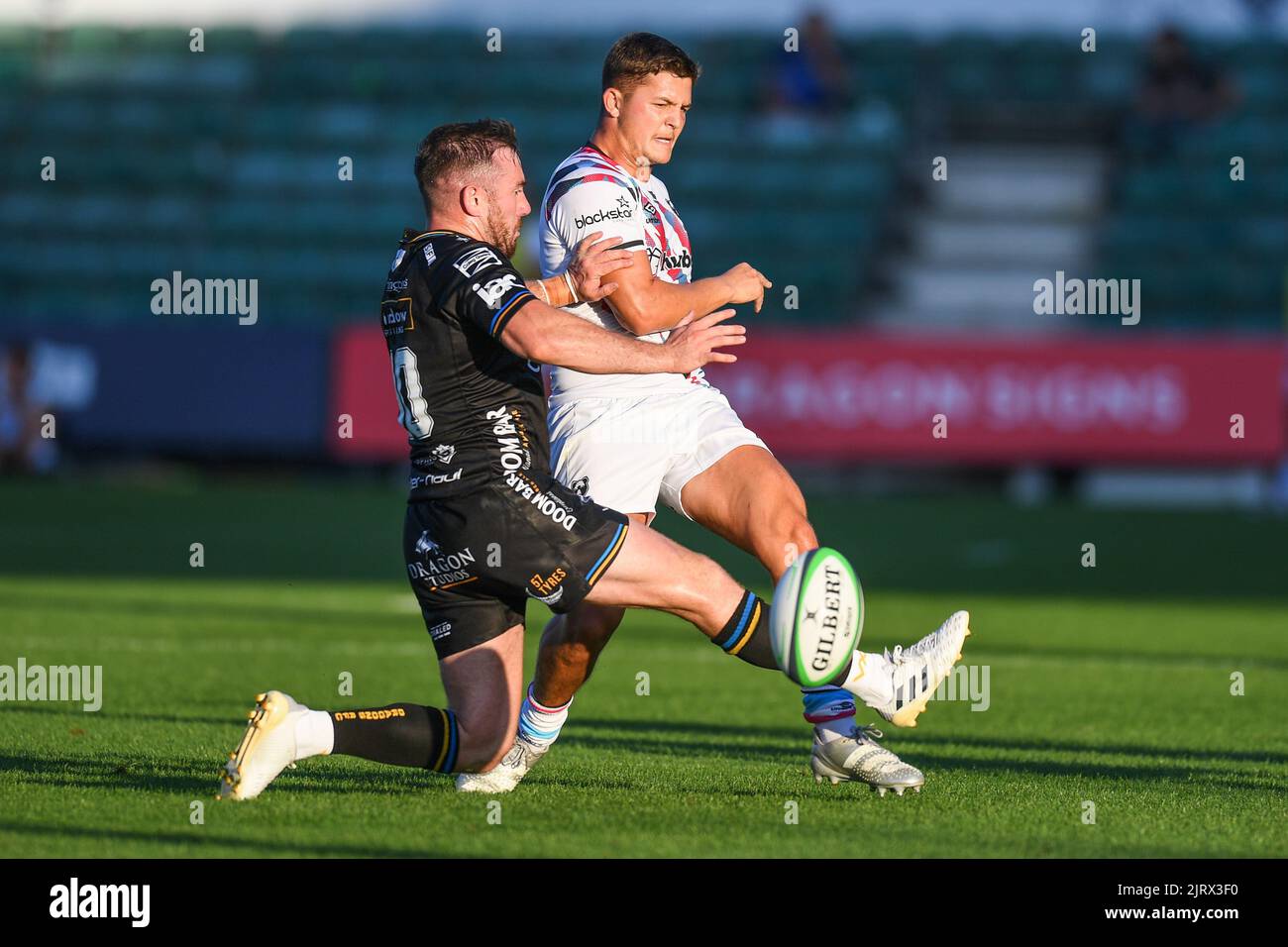 Callum Sheedy of Bristol Bears kicks the ball ahead under pressure from ...