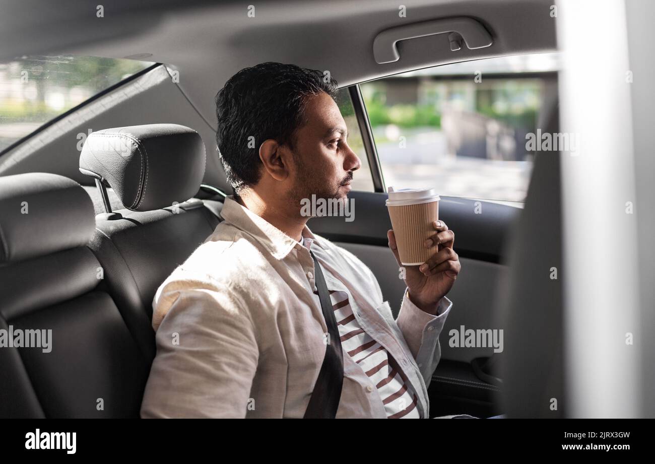 indian man with takeaway coffee on car back seat Stock Photo - Alamy