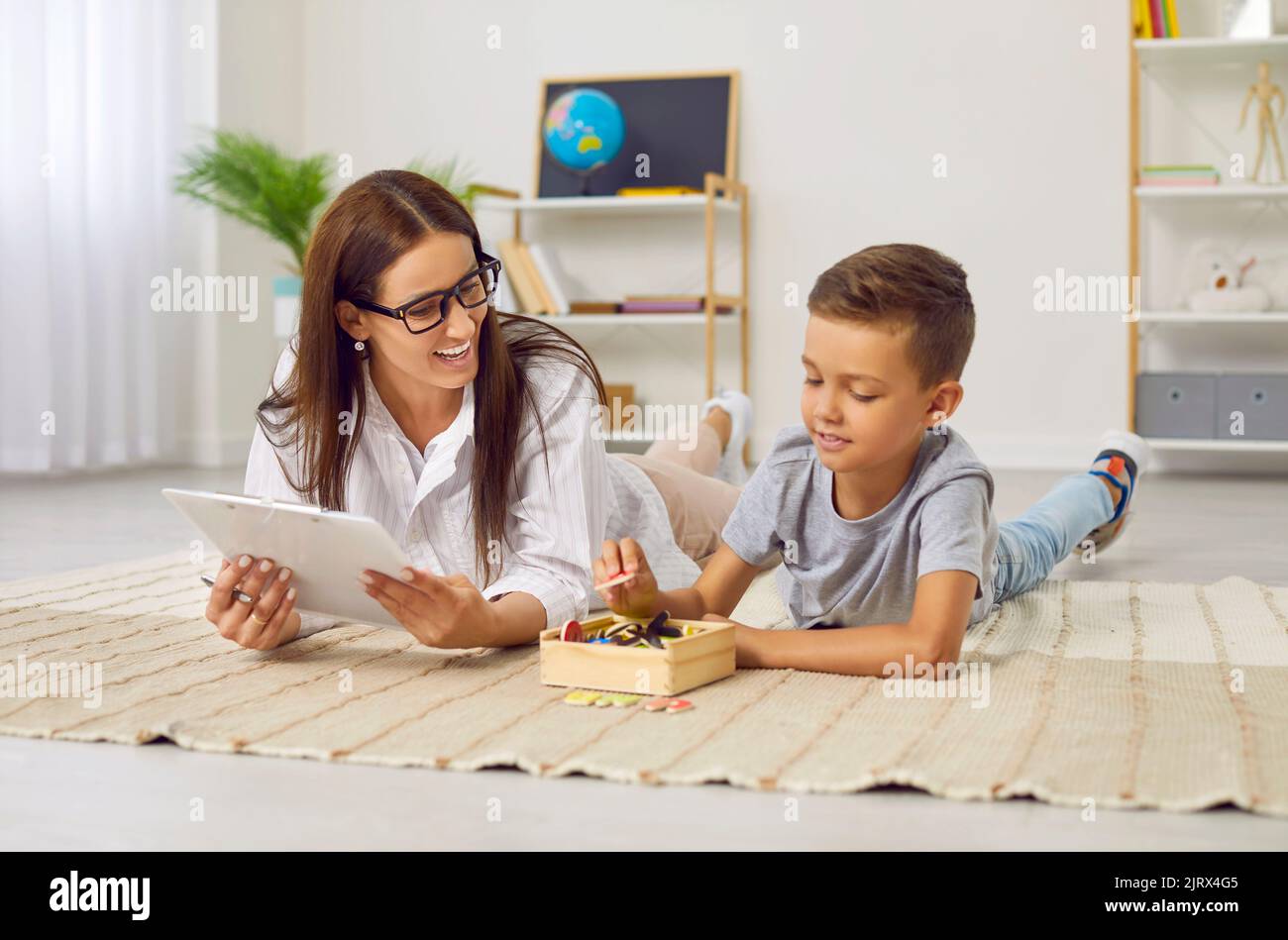 Happy boy having fun while learning letters with a professional speech ...