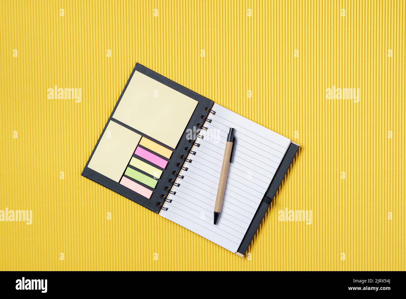 School notebook on a paper yellow background, spiral notepad and craft ...