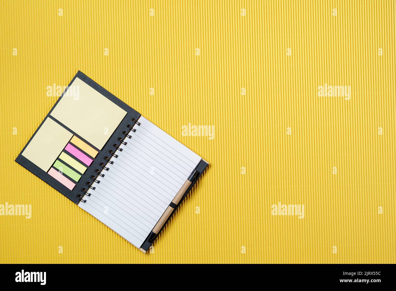 School notebook on a paper yellow background, spiral notepad and craft ...