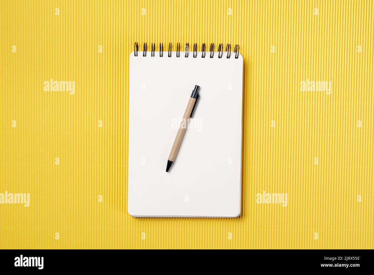 School notebook on a paper yellow background, spiral notepad and craft ...