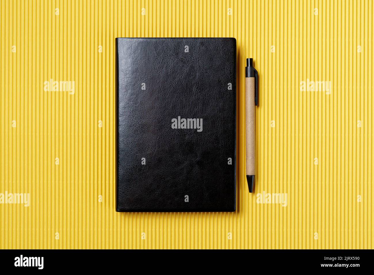 Black leather notebook on a paper yellow background, notepad mock up ...