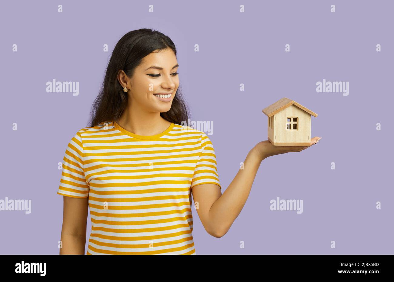 Woman who dreams of owning house, holding mock-up of house isolated on ...