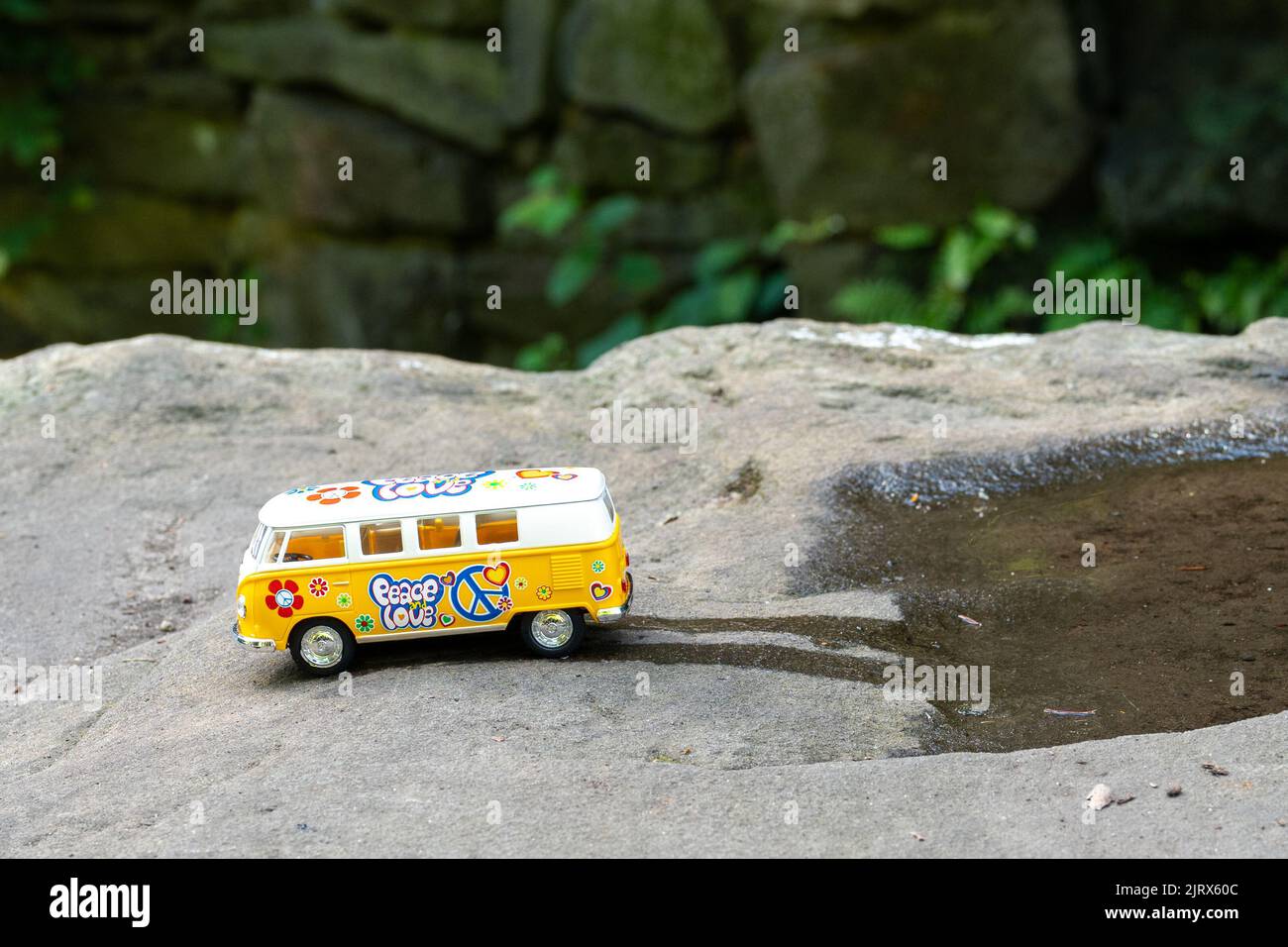 Yellow VW camper van model bus, in a nature scene, on a rock, driving ...