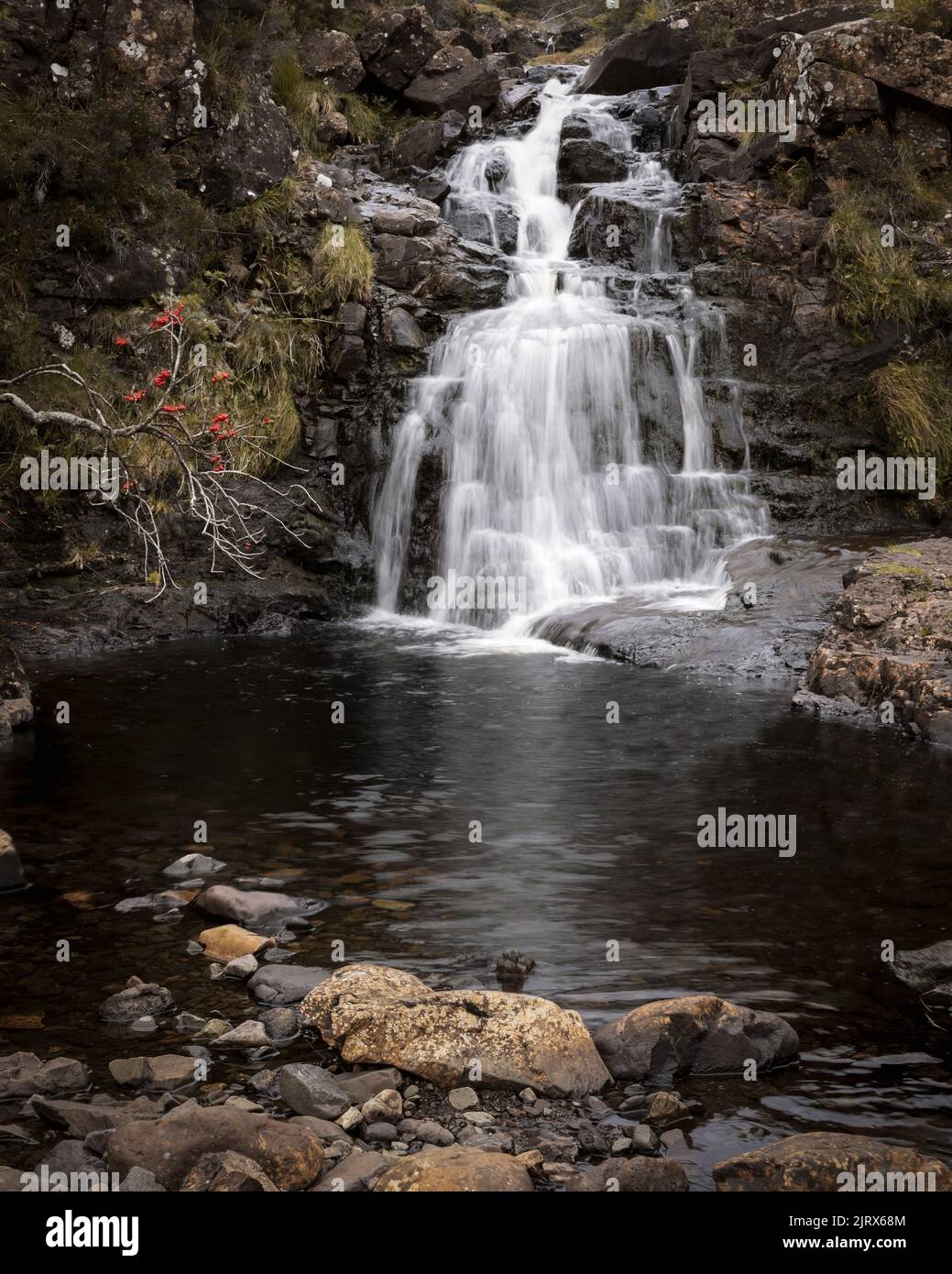 The beautiful vertical view of the waterfall flowing over the rocky ...