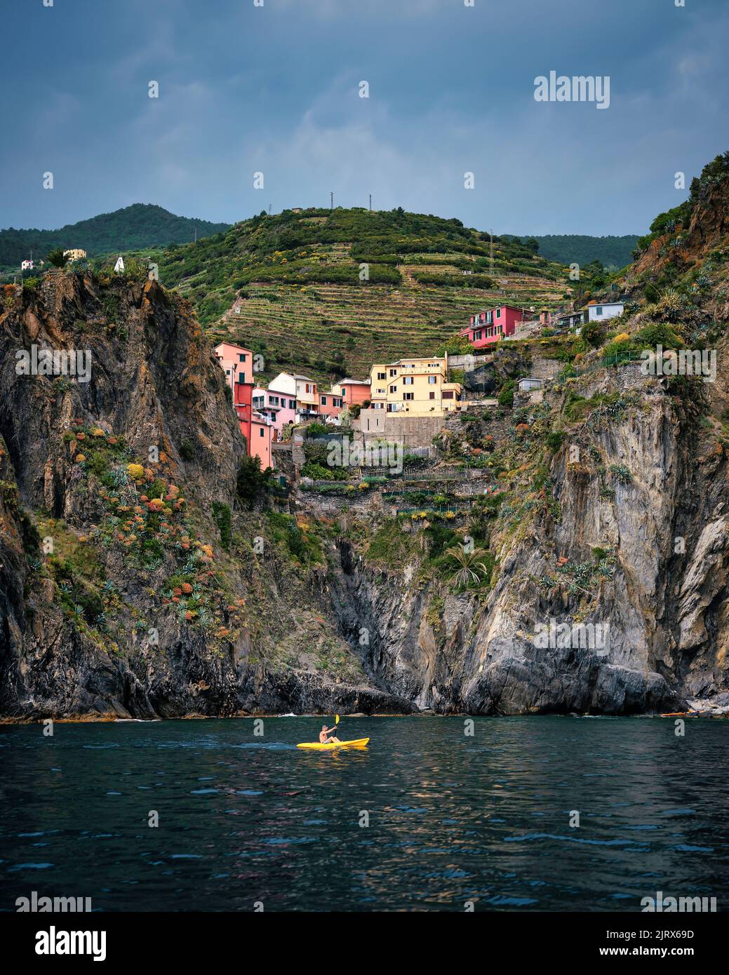 The vertical view of colorful seaside buildings between the slopes in ...