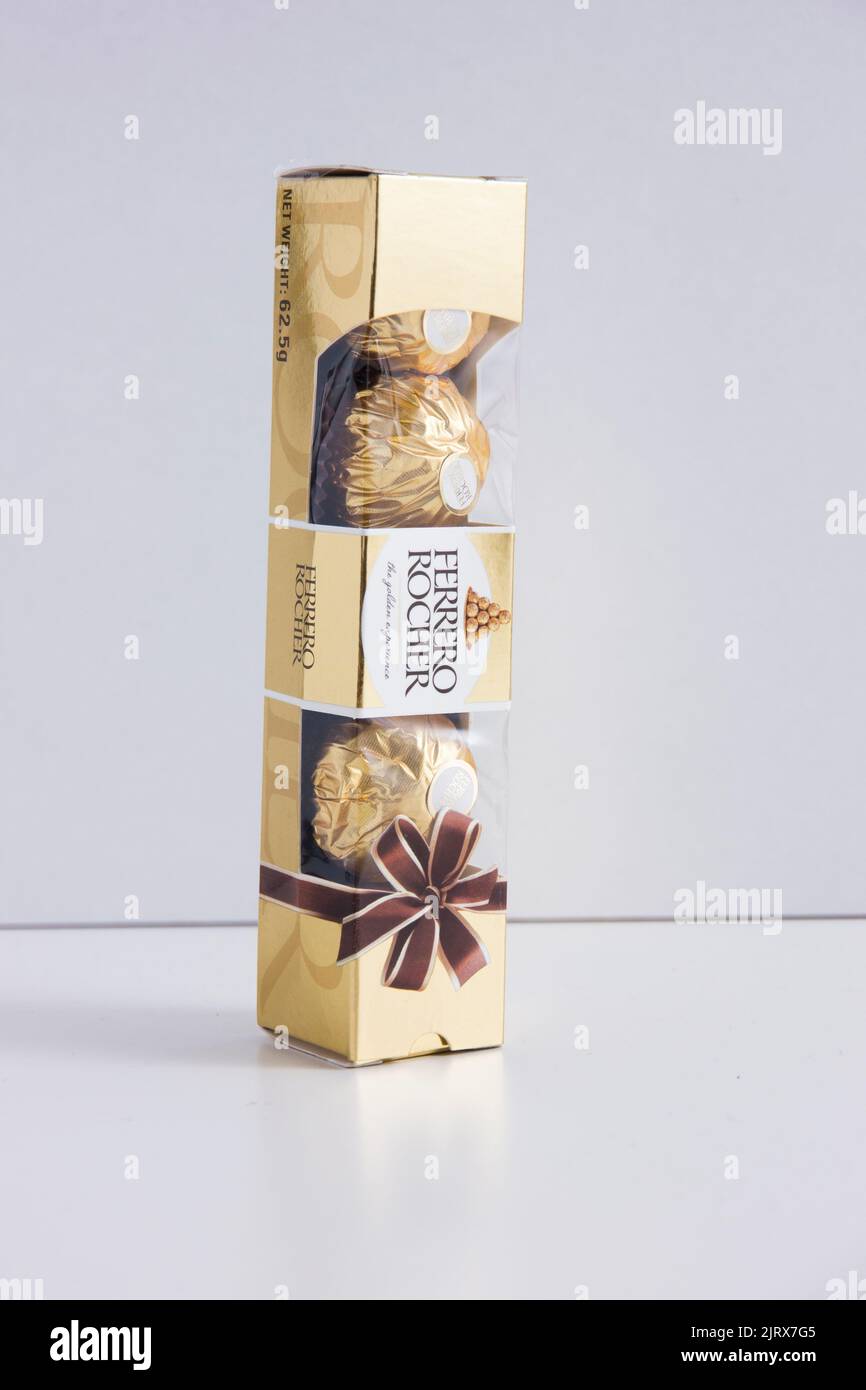 A vertical of a box chocolate of Ferrero Rocher on a white table Stock ...
