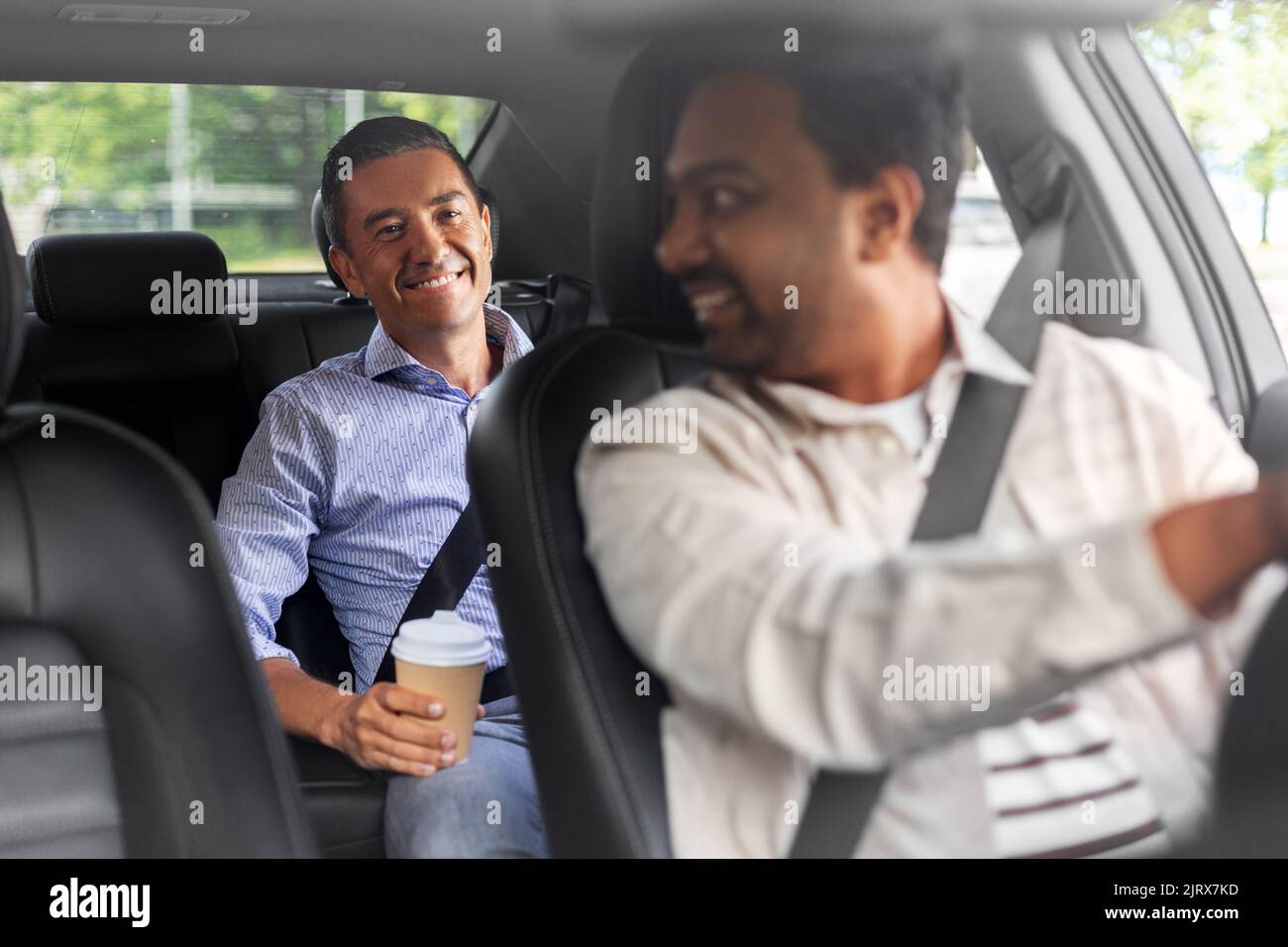 male passenger with coffee talking to car driver Stock Photo - Alamy
