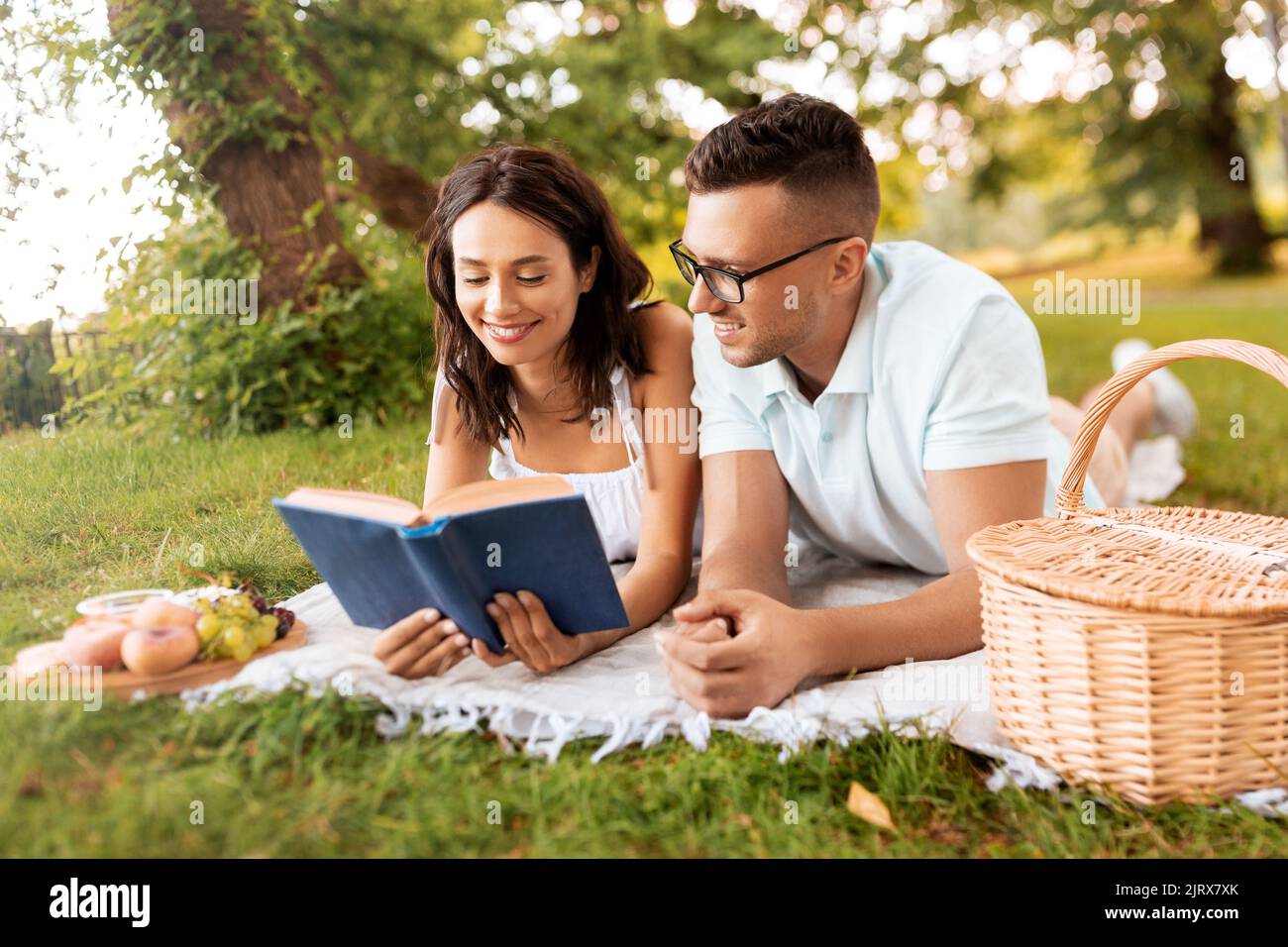 happy couple reading book on picnic at summer park Stock Photo - Alamy
