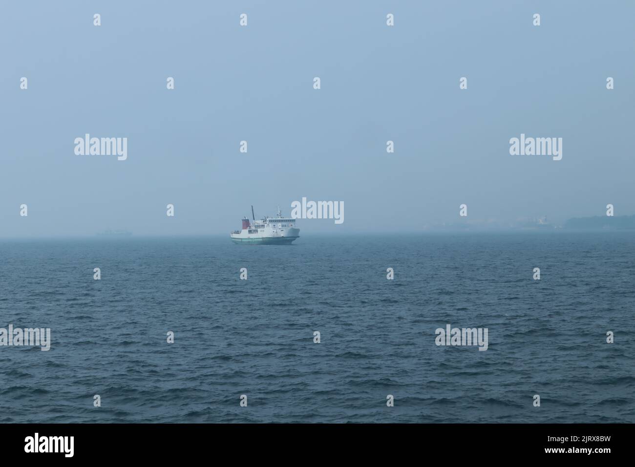 A beautiful view of a ship in a calm sea on a cloudy day Stock Photo ...