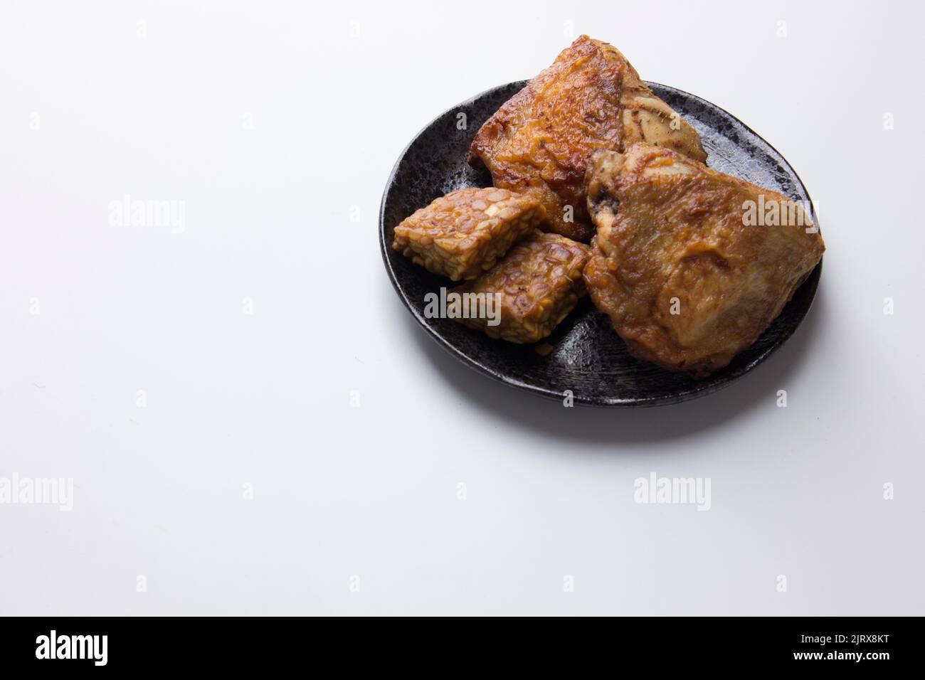 A closeup shot of crispy fried chicken on the black plate ready to ...