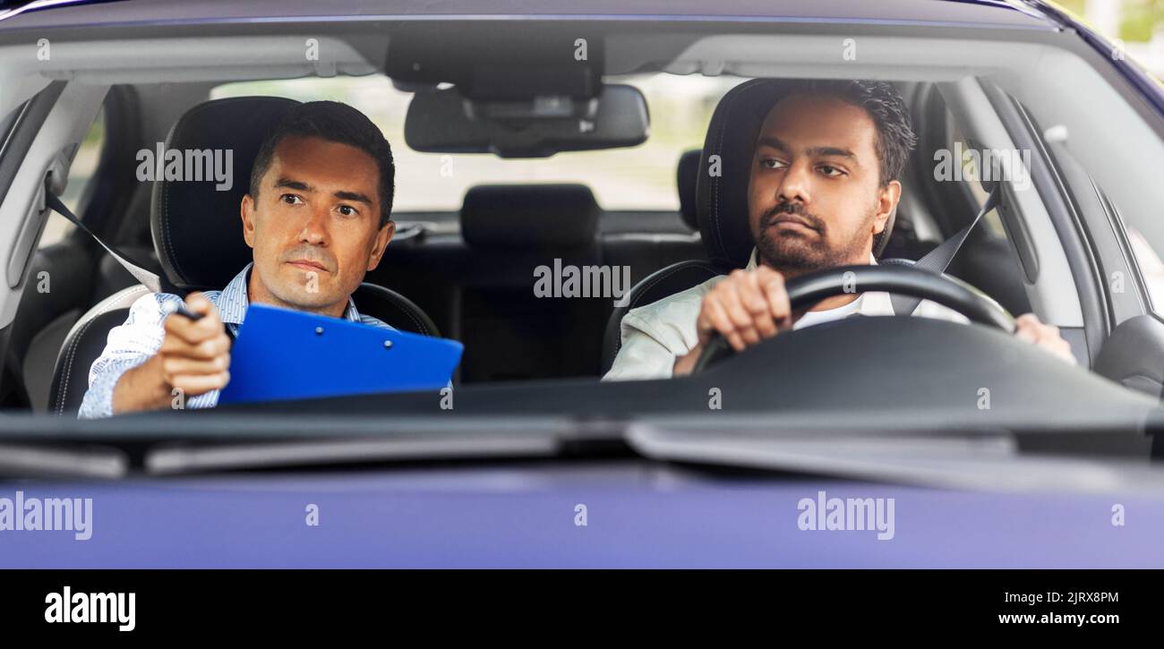 car driving school instructor and young driver Stock Photo - Alamy