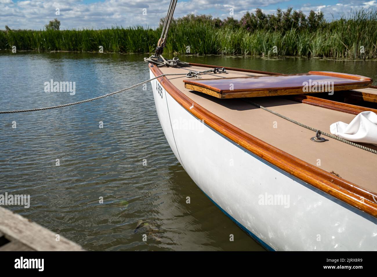 The front end or bow of a traditional sailing boat moored against the ...