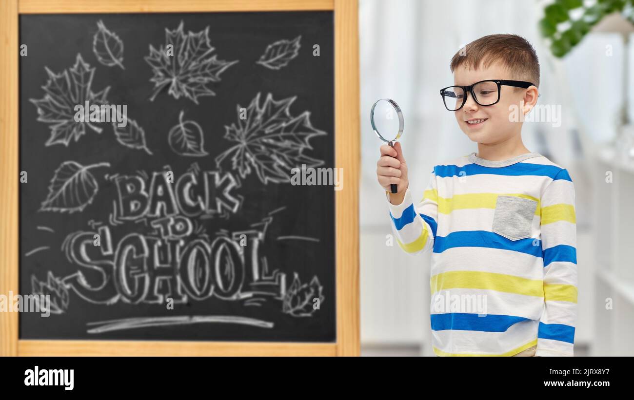 little student boy with magnifying glass Stock Photo - Alamy