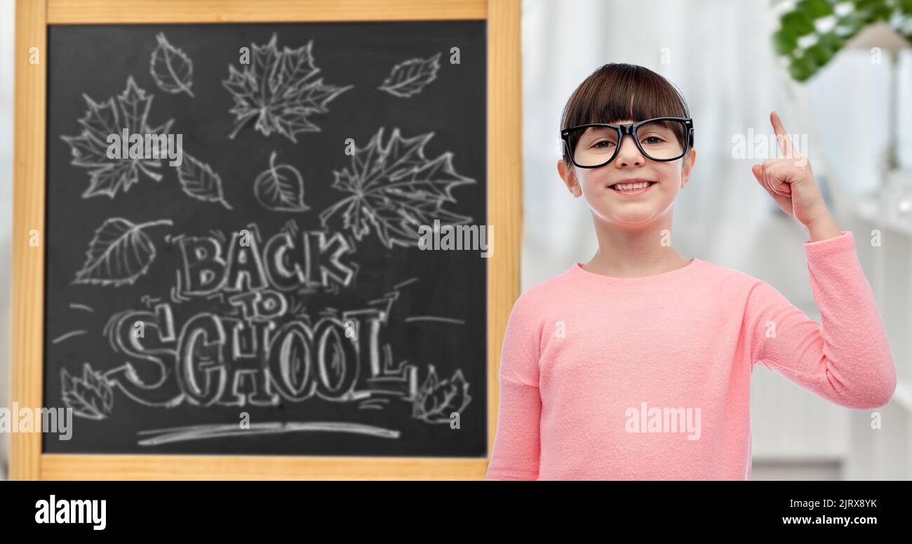 little student girl in glasses pointing finger up Stock Photo - Alamy